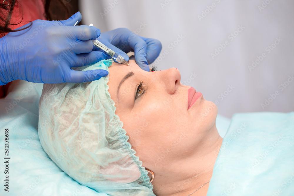 Injection facial rejuvenation. The cosmetologist injects cosmetic ...