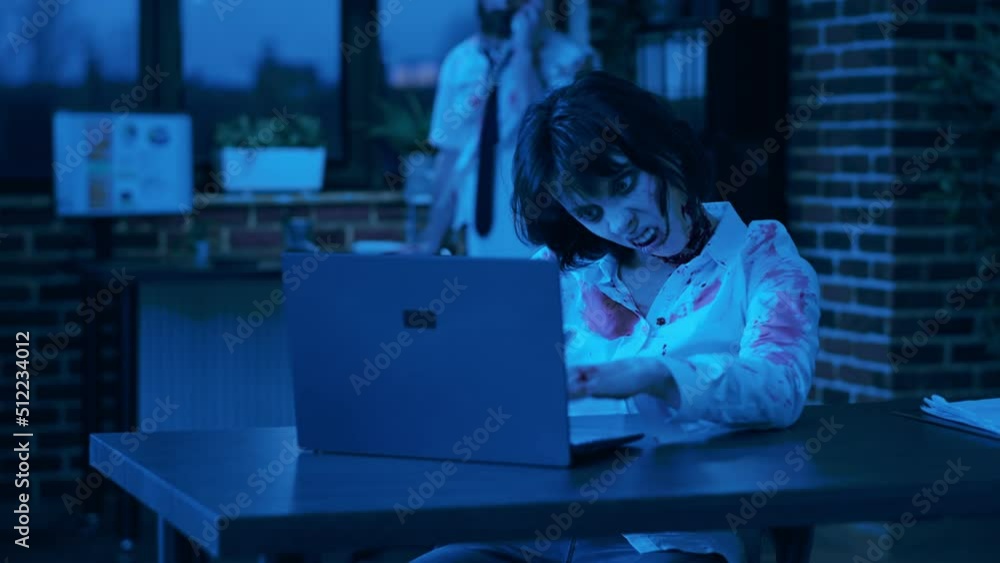Creepy looking office zombie woman working on modern laptop while ...