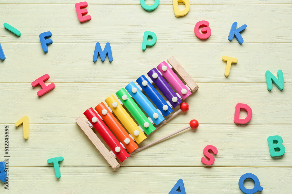 Xylophone toy and letters on yellow wooden background Stock Photo ...