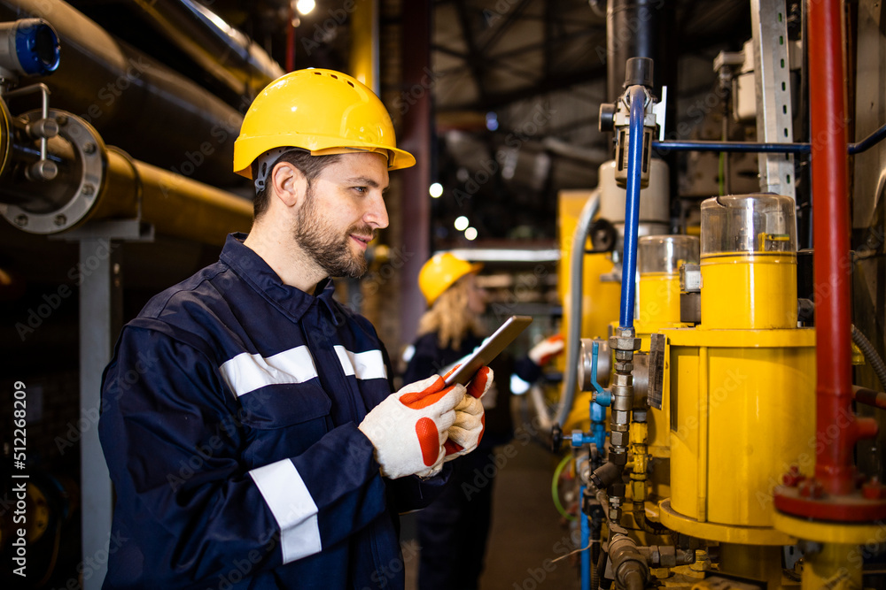 Industrial workers working together in power plant controlling gas ...