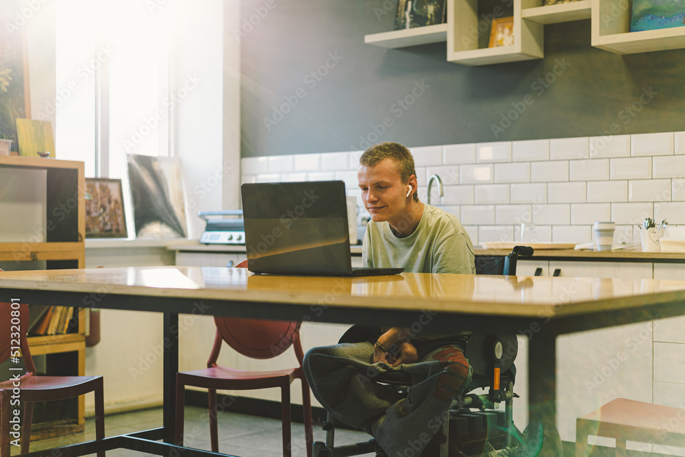 Handsome young invalid disabled man talking on mobile phone in kittchen ...