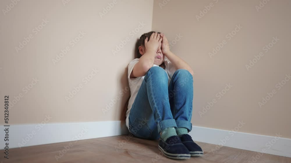 sad girl sitting in the corner crying a covered her face with her ...