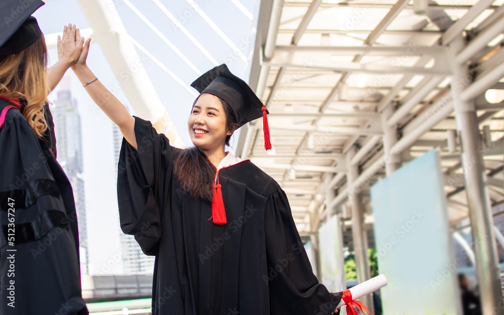 Two asian female students wearing uniform, cap and smiling with ...