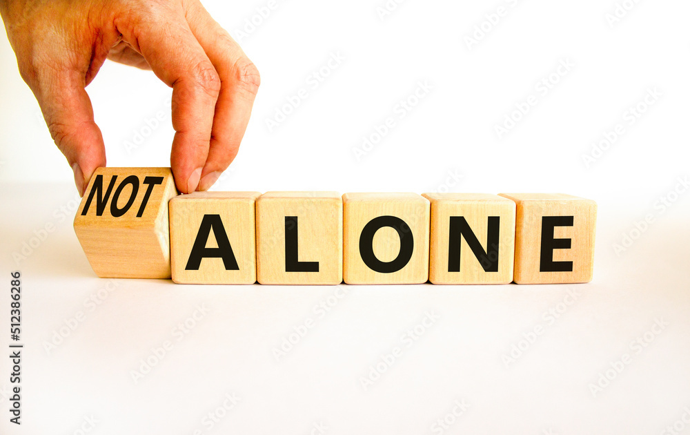 You are not alone symbol. Businessman turns wooden cubes and changes ...