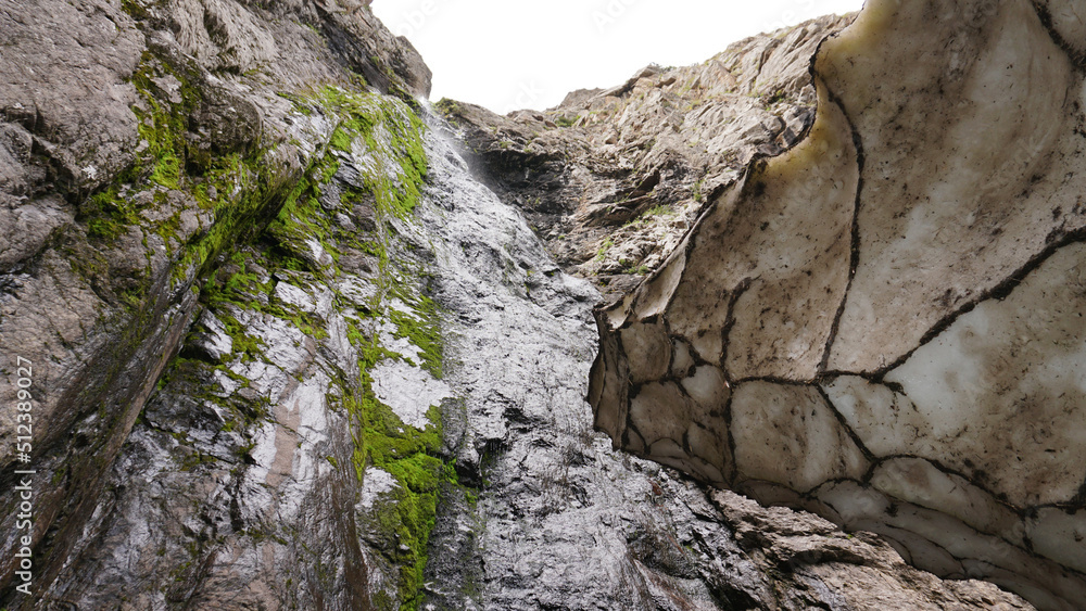 Ice grotto, a snow cave in the mountains in summer. Drops drip from the ...