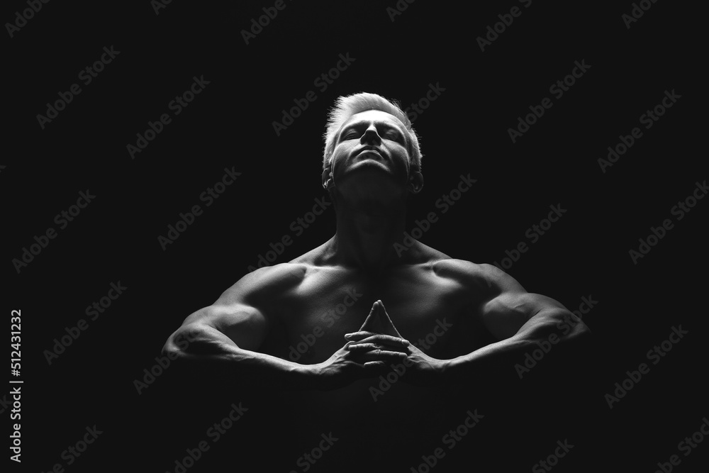 Handsome power athletic man in dramatic light. Strong bodybuilder with ...