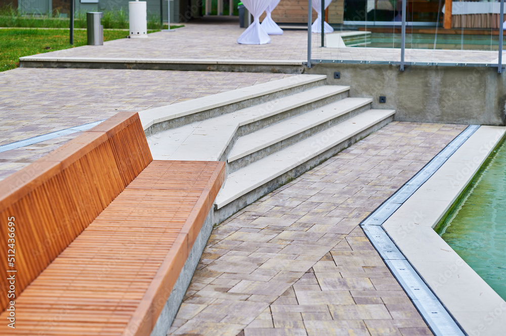 wooden seat leading path to steps along a stone path in landscape ...