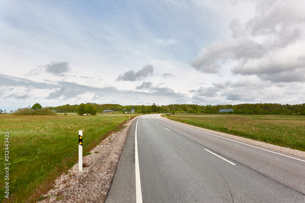 An empty highway (new asphalt road) through the rural area and forest ...