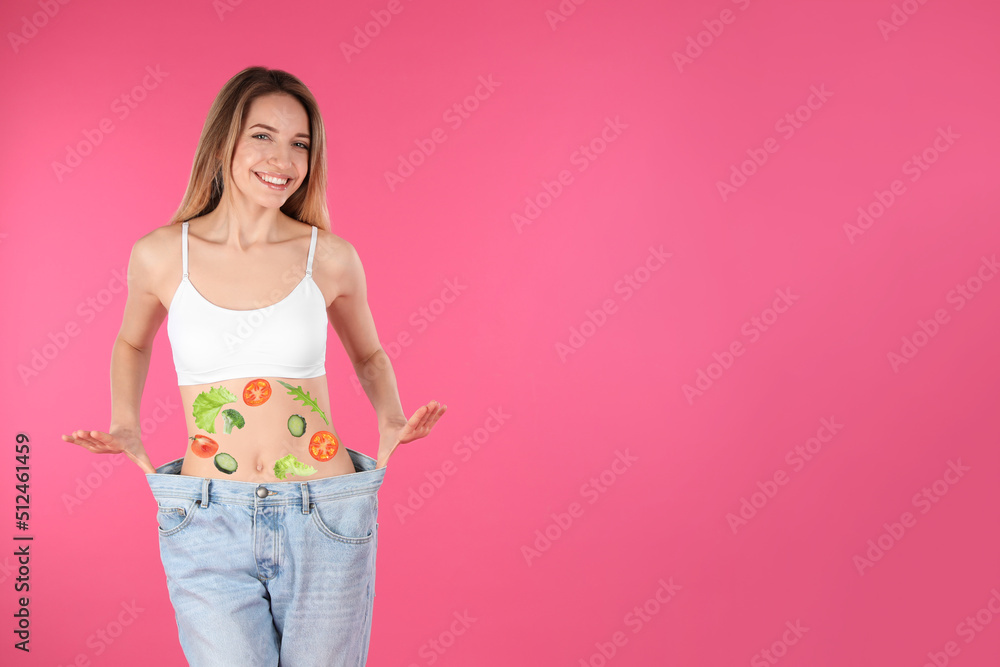 Slim woman in oversized jeans and images of vegetables on her belly ...