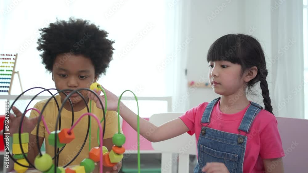 Little kindergarten kids playing together in the class, little children ...