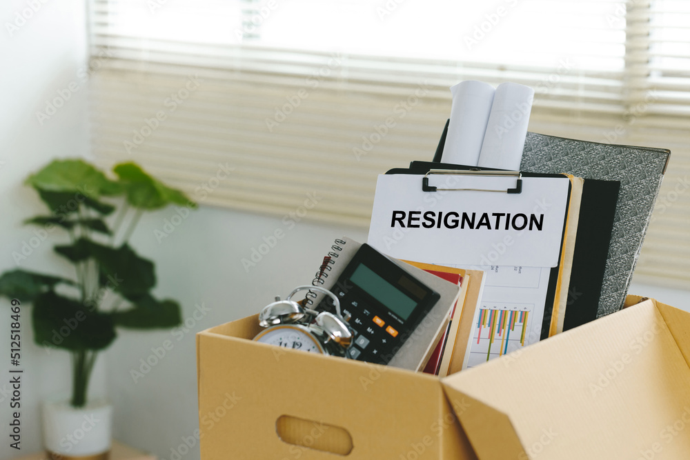Resignation.Letter of resignation and cardboard box on the desk ...