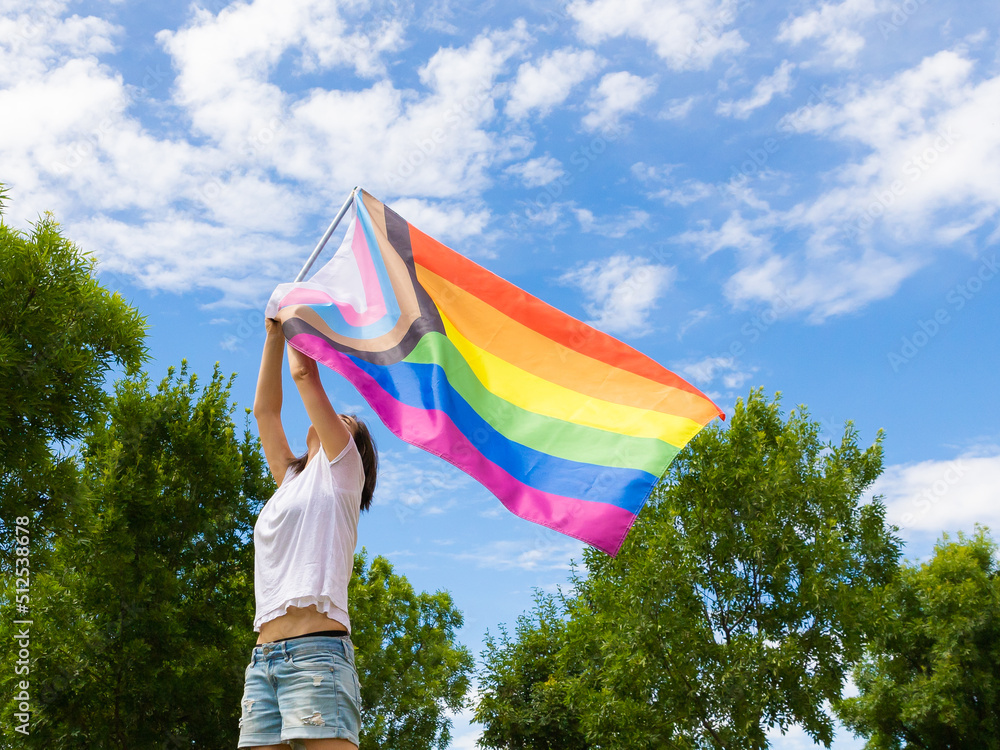 Pride month. Young lesbian girl waving the lgbtiq+ flag on the pride ...