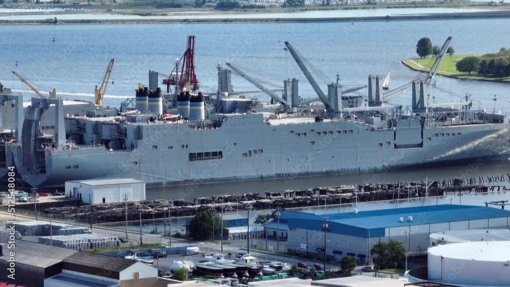 Large cargo freighter ship at dock in port. Bulk fuel tank storage in ...