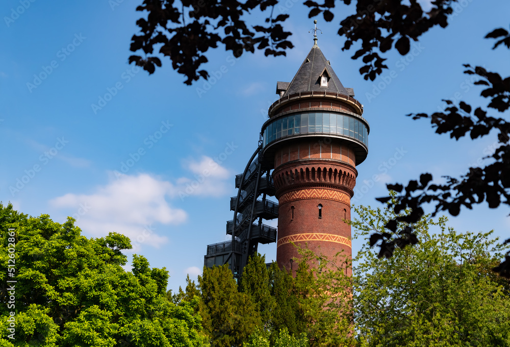 Historic water supply tower with red brick facade on a sunny summer day ...
