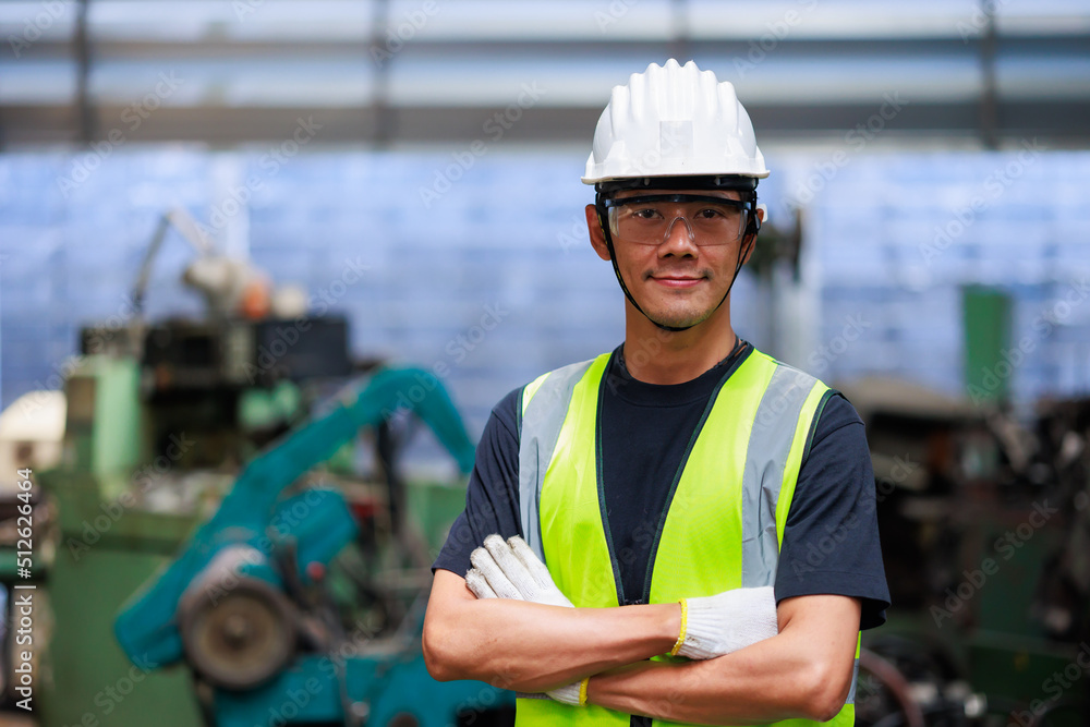 Confident Asian man worker look at camera thumps up. Metal machine in ...