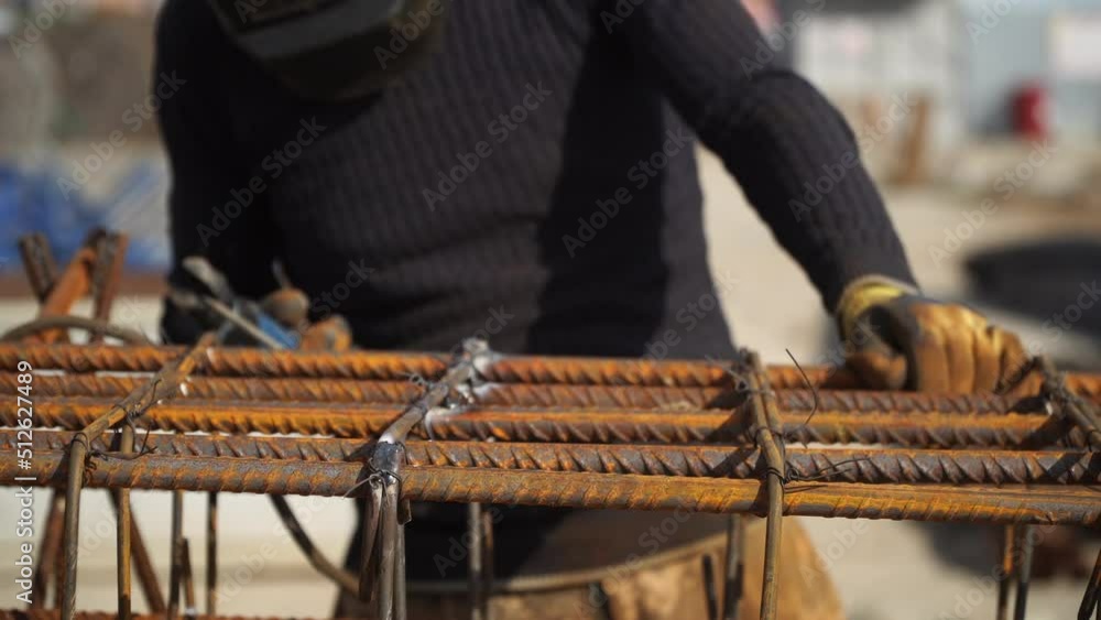 Welder in welding mask and welding gloves welds metal structure on ...