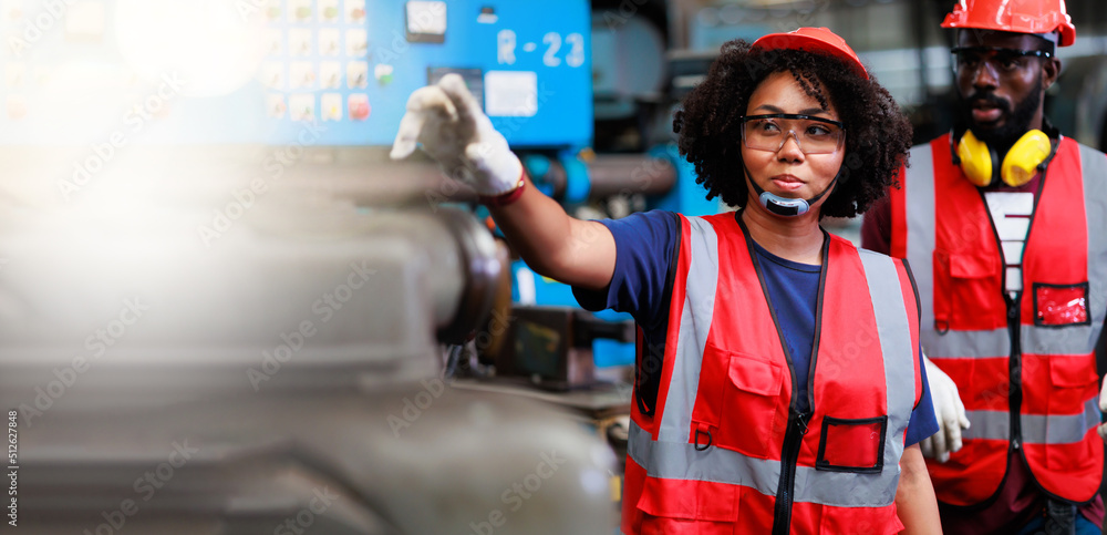 Black Woman worker wearing safety goggles control lathe machine to ...