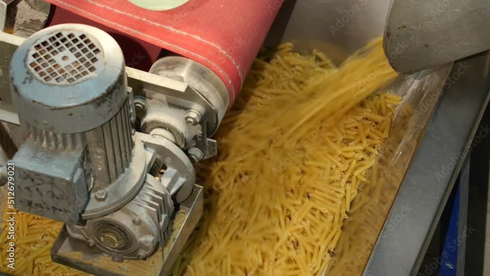 Macaroni factory. Production cycle of making pasta. Pasta is pouring ...