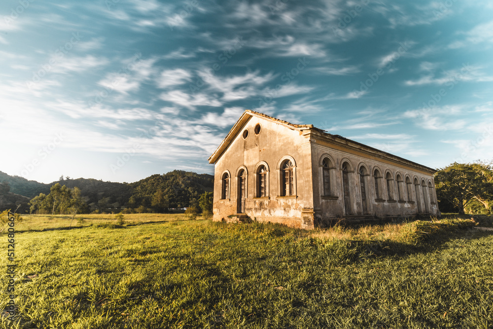 House with colonial architecture, with sun and clouds in the ...