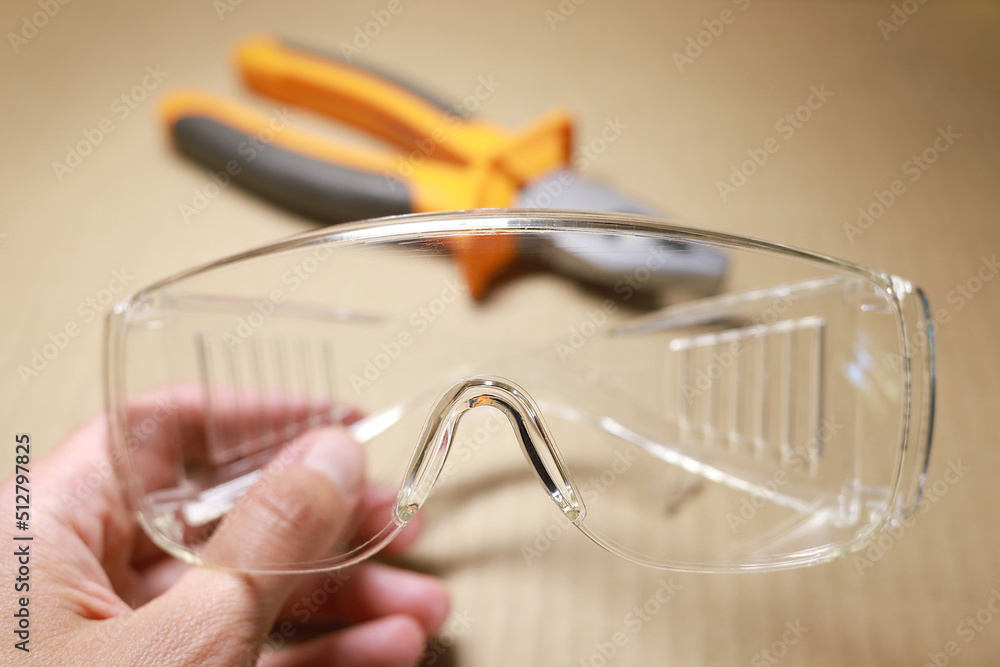 Selective focus of Protective glasses in hand, eye safety. Safety ...