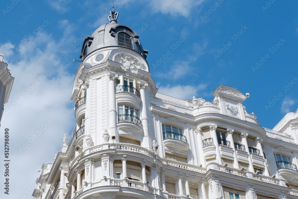 Corner of elegant old building with rounded forms in balconies and ...