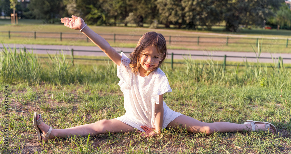 cute little girl is doing artistic gymnastics exercises Stock Photo ...