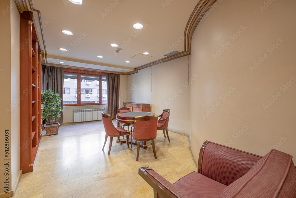 Main area of an office with a round meeting table with wooden furniture ...