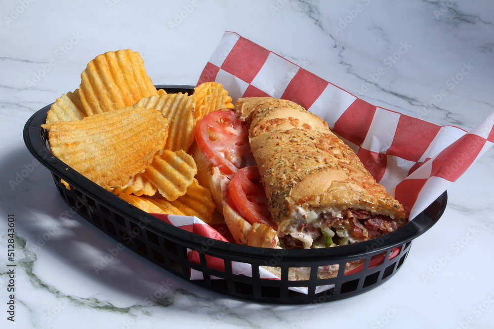 BLT half submarine sandwich with potato chips in a basket. Stock Photo ...