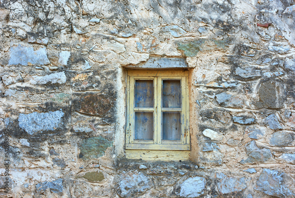 Wooden window on an old rough stone wall farmhouse or ancient house ...