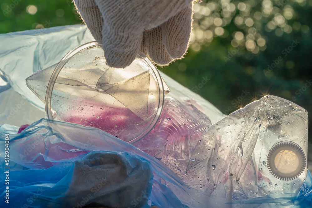 Plastic pollution in the environmental problem of the world. A hand in ...