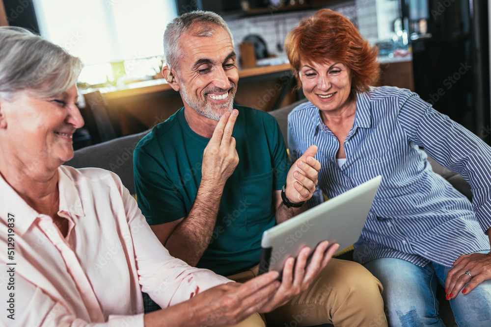 Smiling Deaf man with his friends talking using sign language on the ...
