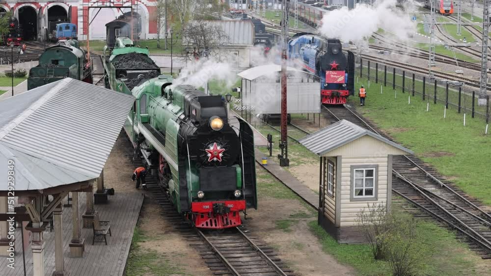 A World War II steam locomotive moves slowly and blows steam. Vintage ...