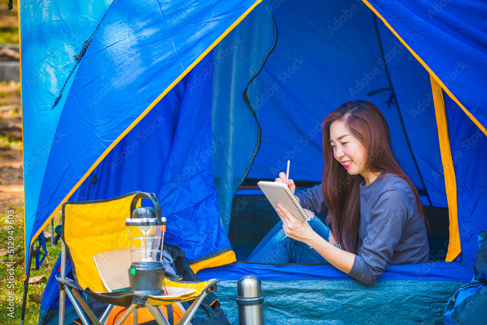 Beautiful lady wearing a blue shiry and jean sitting inside a tent and ...