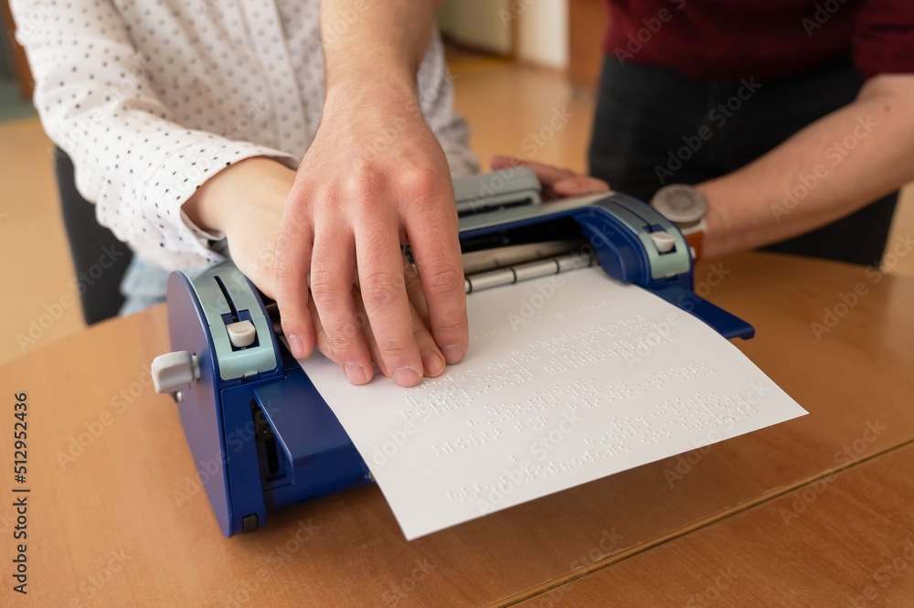 A man teaches a blind woman to type on braille machine. Stock Photo ...
