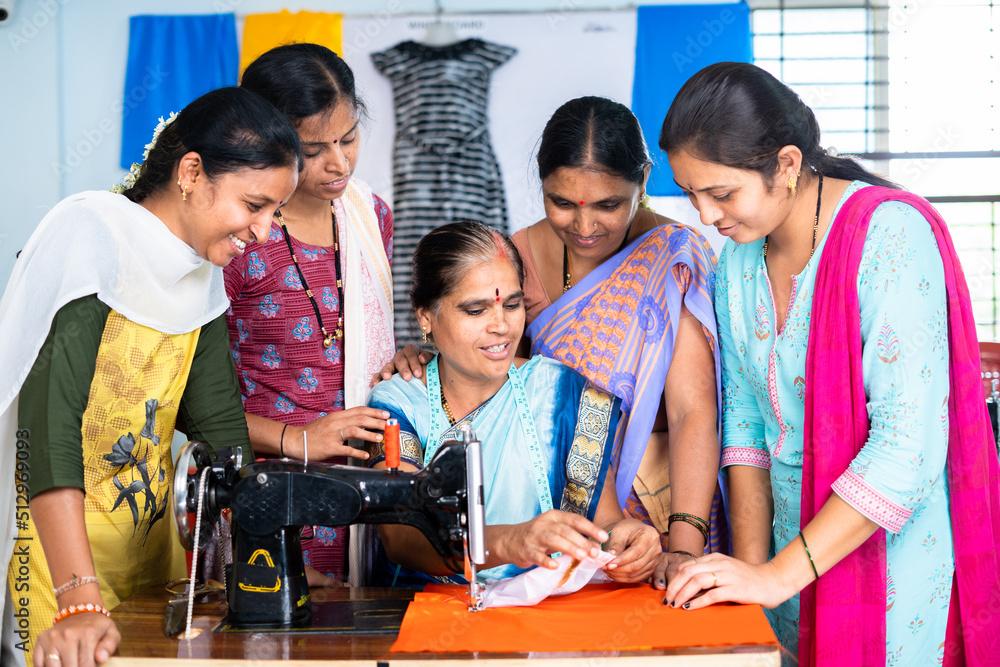 group of woman at tailoring class discuissing with teacher about cloth ...