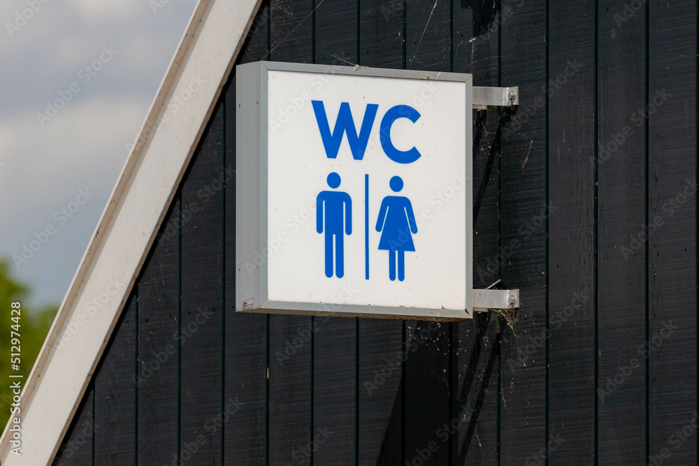 Selective focus of white and blue public toilet sign board on black ...