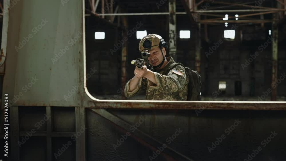 American soldier in safety helmet and uniform aiming through rifle ...