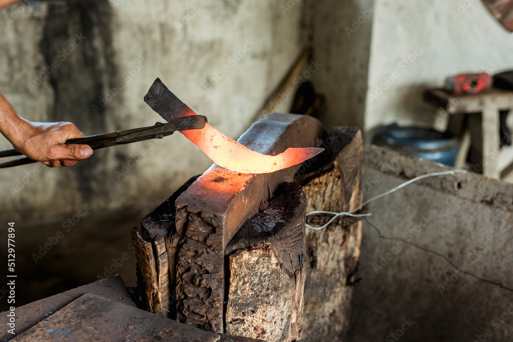 Loay, Bohol, Philippines - A local blacksmith forges and shapes a bolo ...