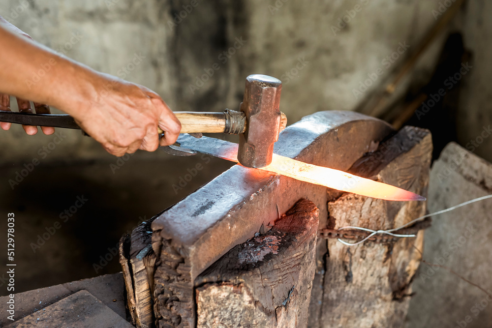 Loay, Bohol, Philippines - A local blacksmith forges and shapes a bolo ...