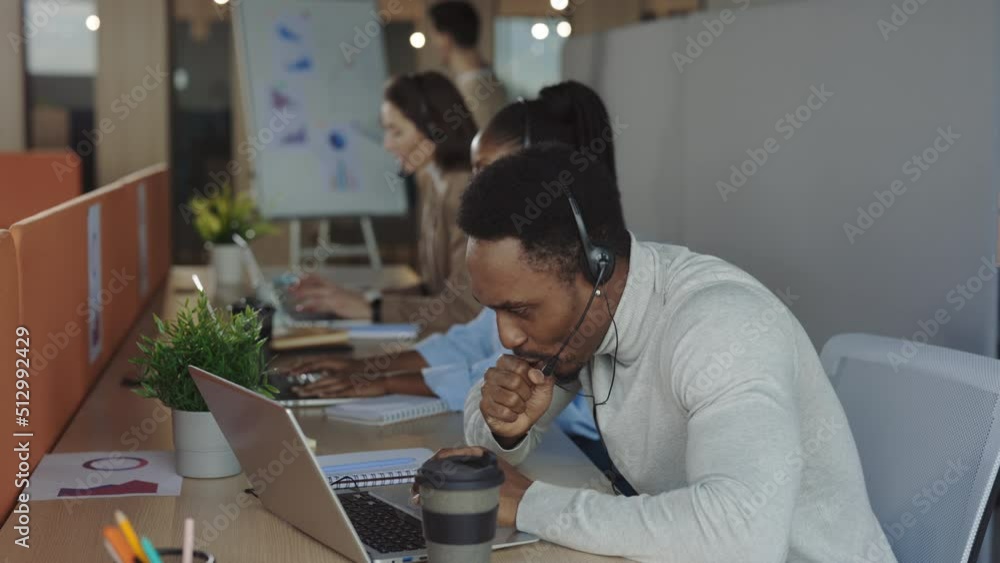 Vidéo Stock African american man in headset coughing after long ...