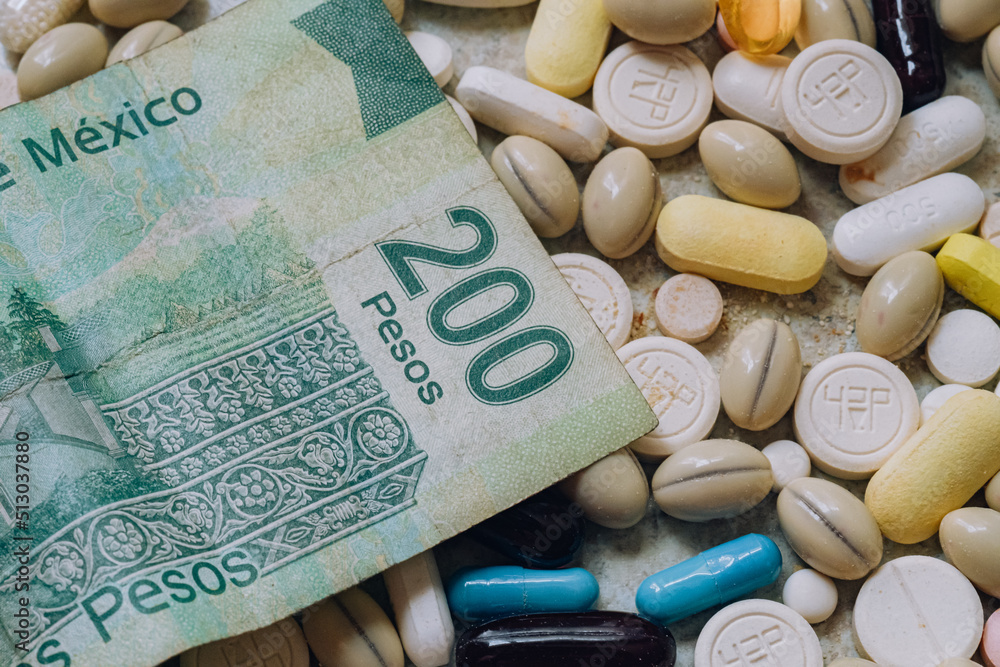 Photo of a Mexican 200 peso bill among pills of many shapes and colors ...
