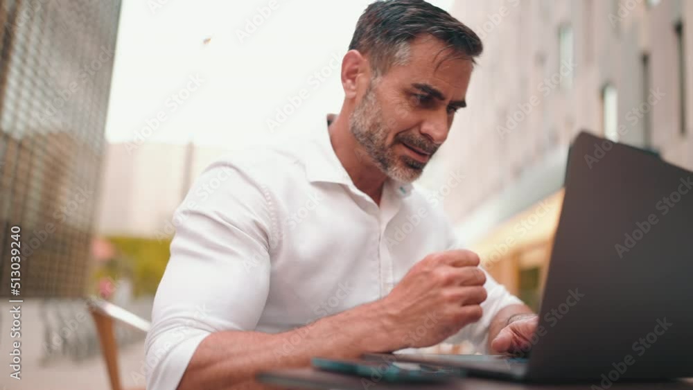Mature businessman with beard user on laptop pc computer sit at cafe ...