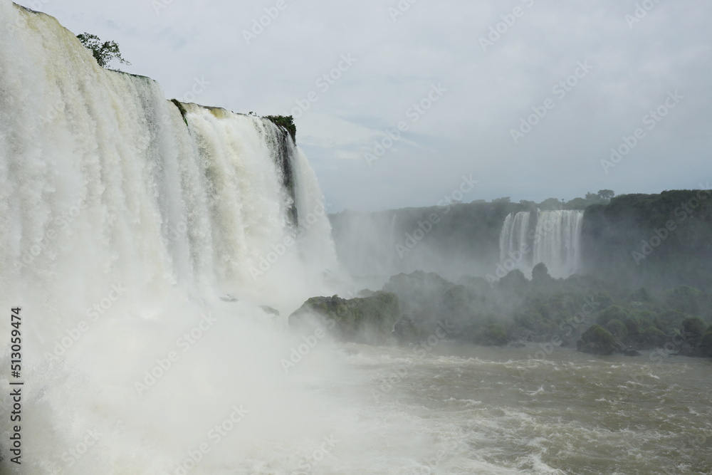 The photo shows a beautiful landscape of Iguazu Falls — a complex of ...