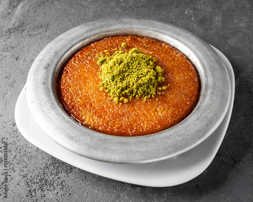 Turkish dessert kunefe, kunafa, kadayif with pistachio powder and ...