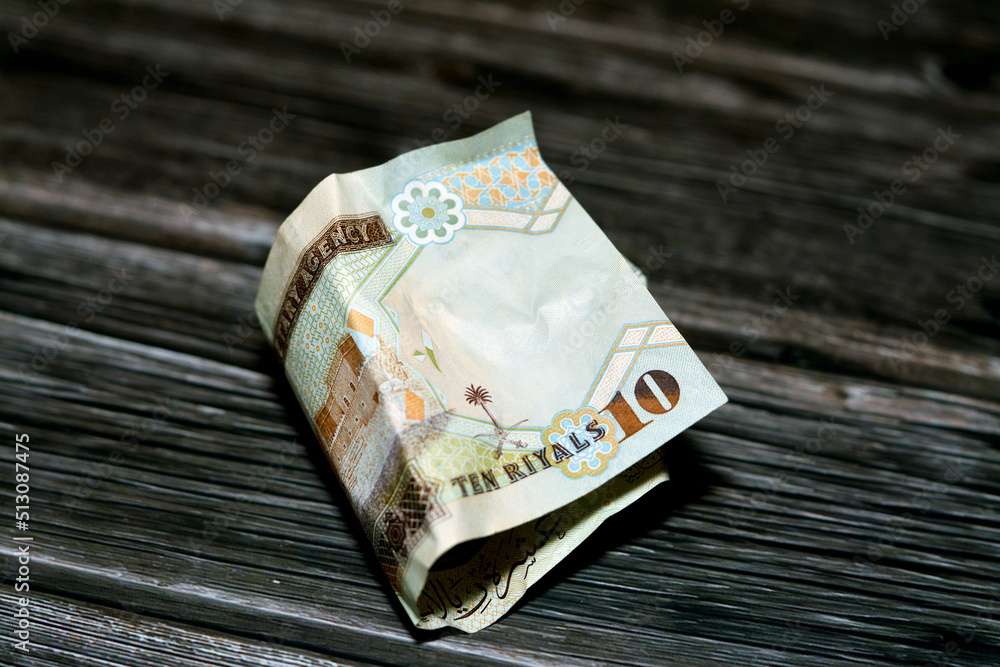 Folded Saudi Arabia money of 10 SAR ten riyals isolated on wooden ...