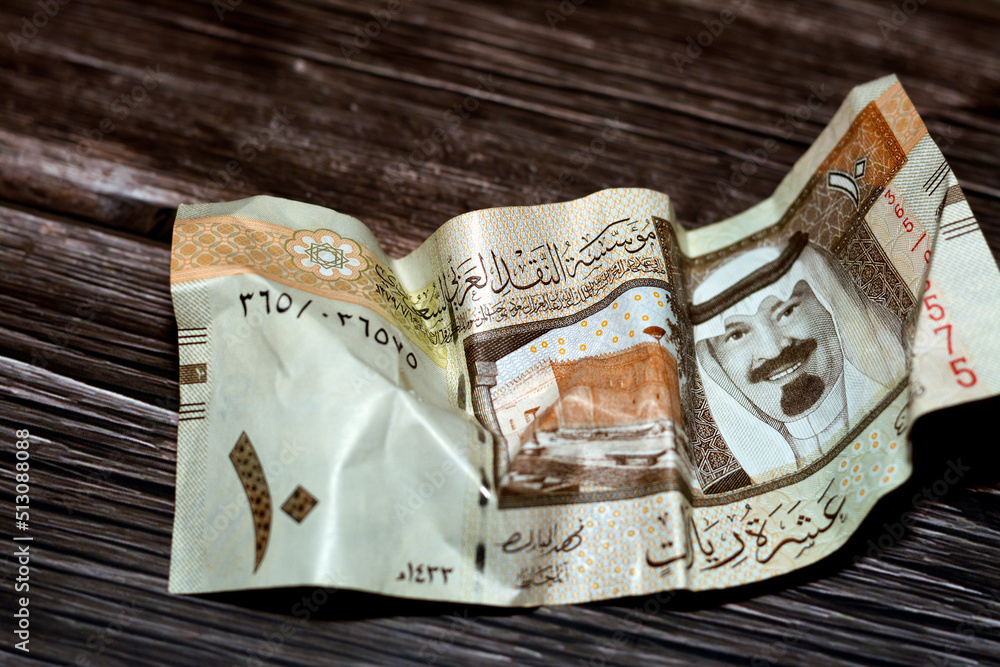 Crumpled Saudi Arabia money of 10 SAR ten riyals isolated on wooden ...