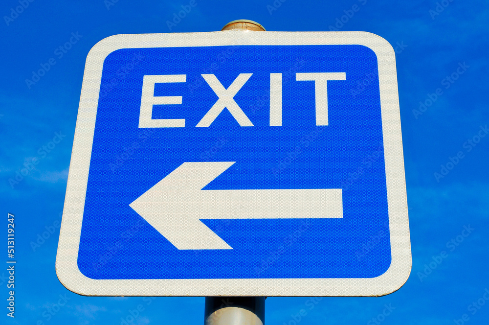 Exit road sign with arrow symbol pointing to the left, against a clear ...