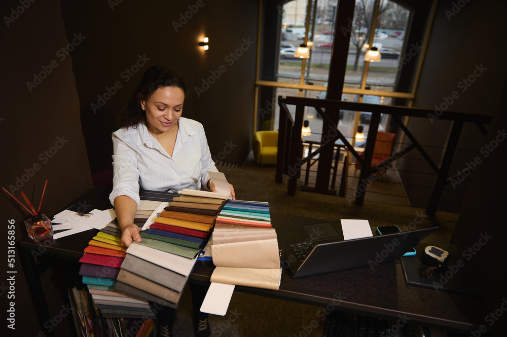 Charming dark-haired woman, interior designer selecting upholstery for ...