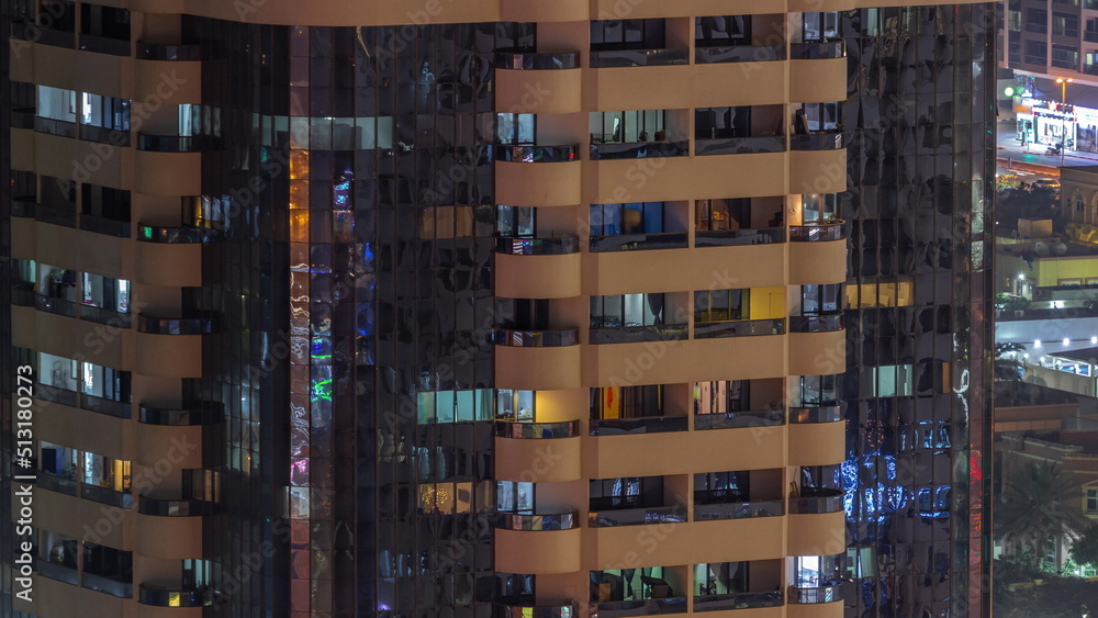 Night aerial view of apartment building glass window facade with ...