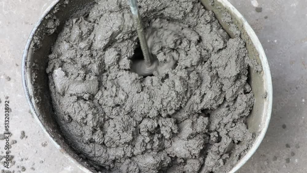 Mixing of concrete mortar.The builder prepares the cement mortar using ...